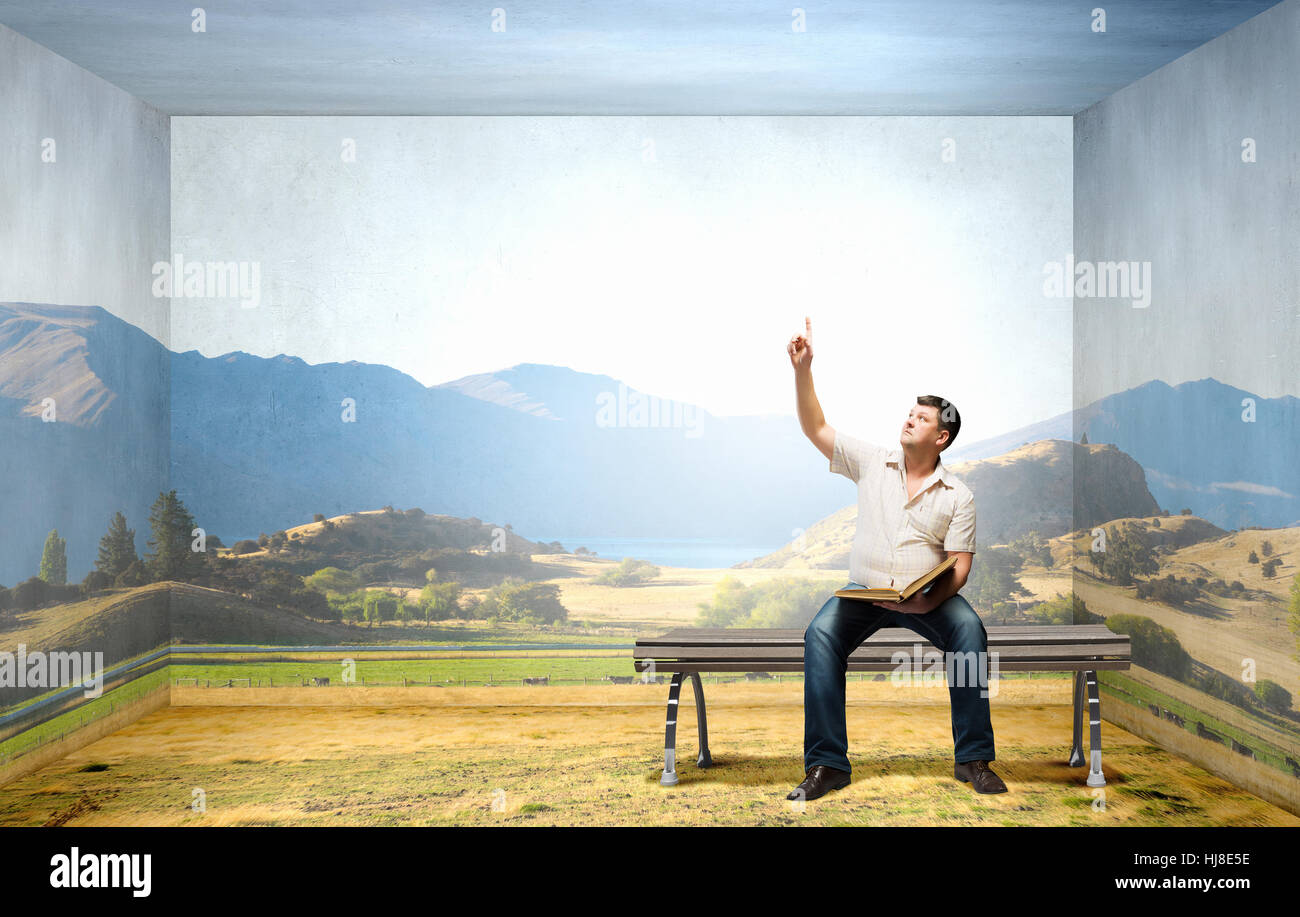 Fat man sitting on bench with book and pointing with finger Stock Photo ...