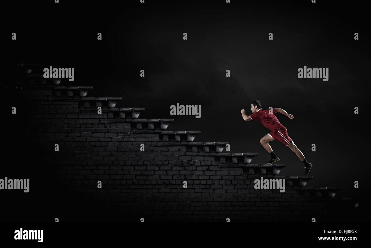 Athlete man in red sport wear running up staircase Stock Photo - Alamy