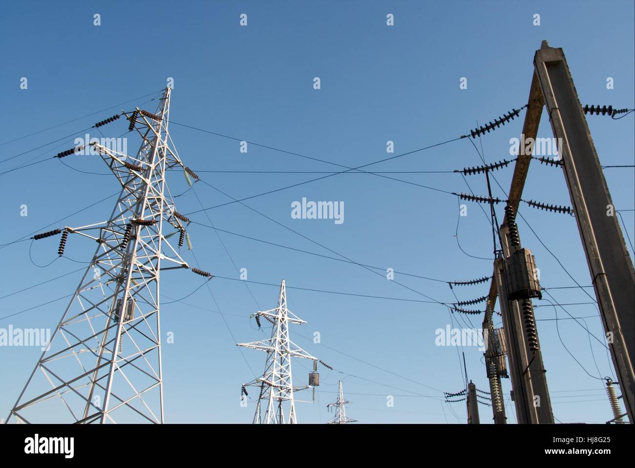 Electric pillars from low angle against clear blue sky Stock Photo - Alamy