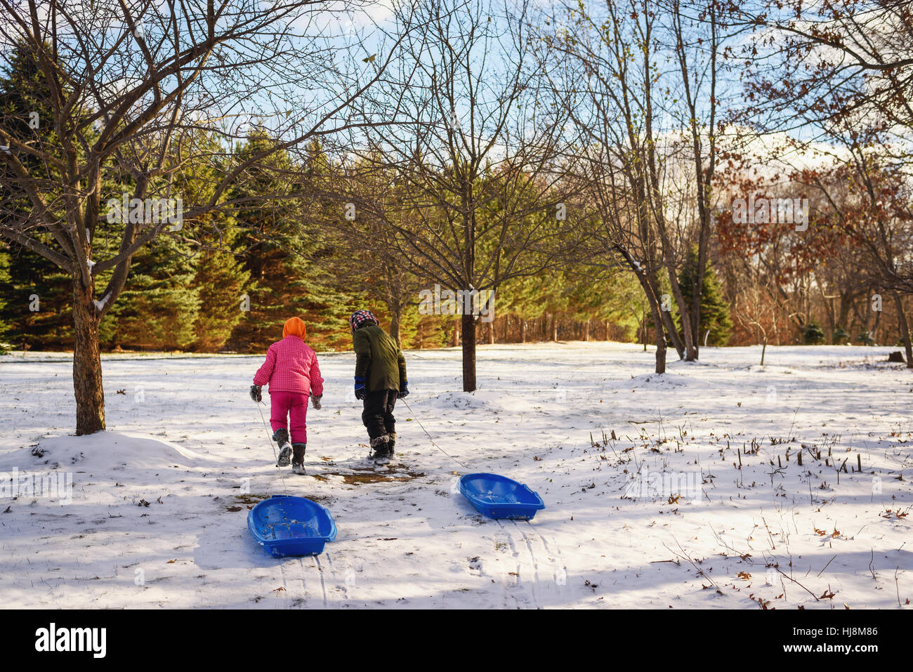Two children pulling sledges hi-res stock photography and images - Alamy