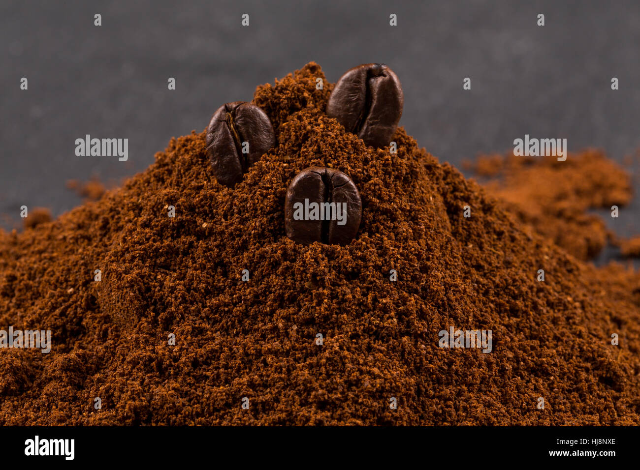 Coffee bean on heap of ground coffee close-up Stock Photo - Alamy