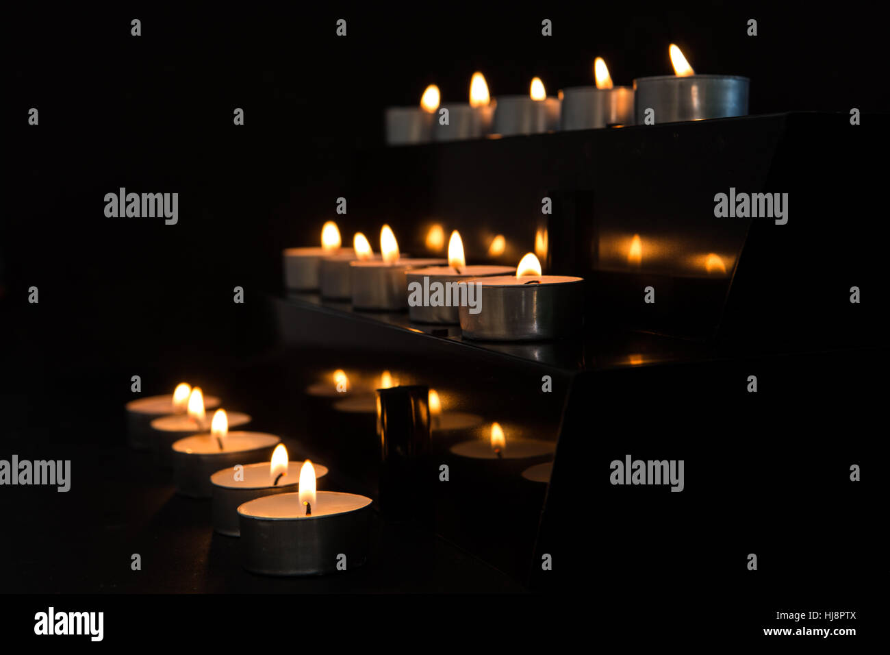 Tea light candles at the alter in the darkness Stock Photo - Alamy
