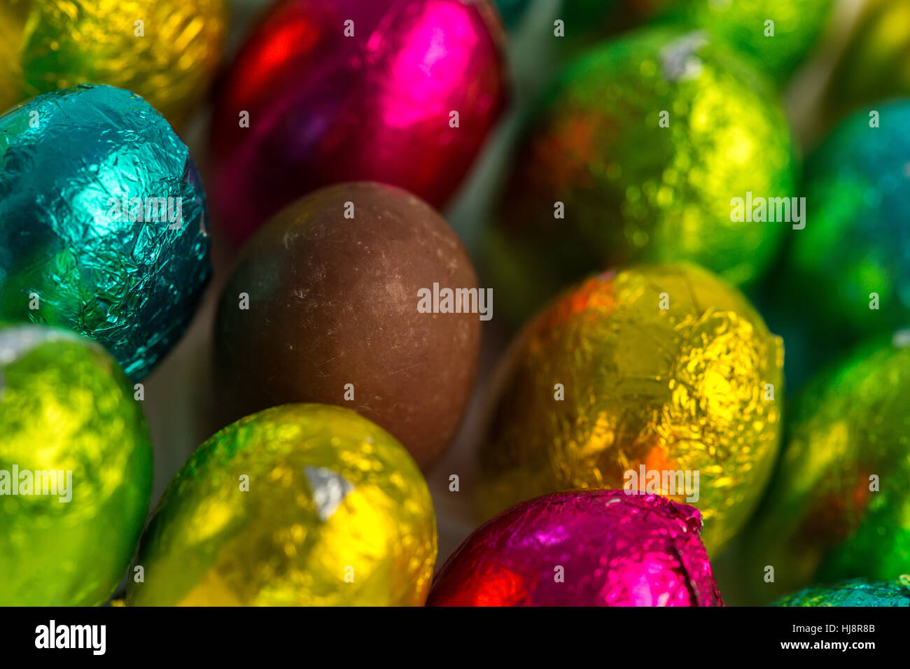 Colourful foil wrapped easter eggs with one unwrapped Stock Photo - Alamy