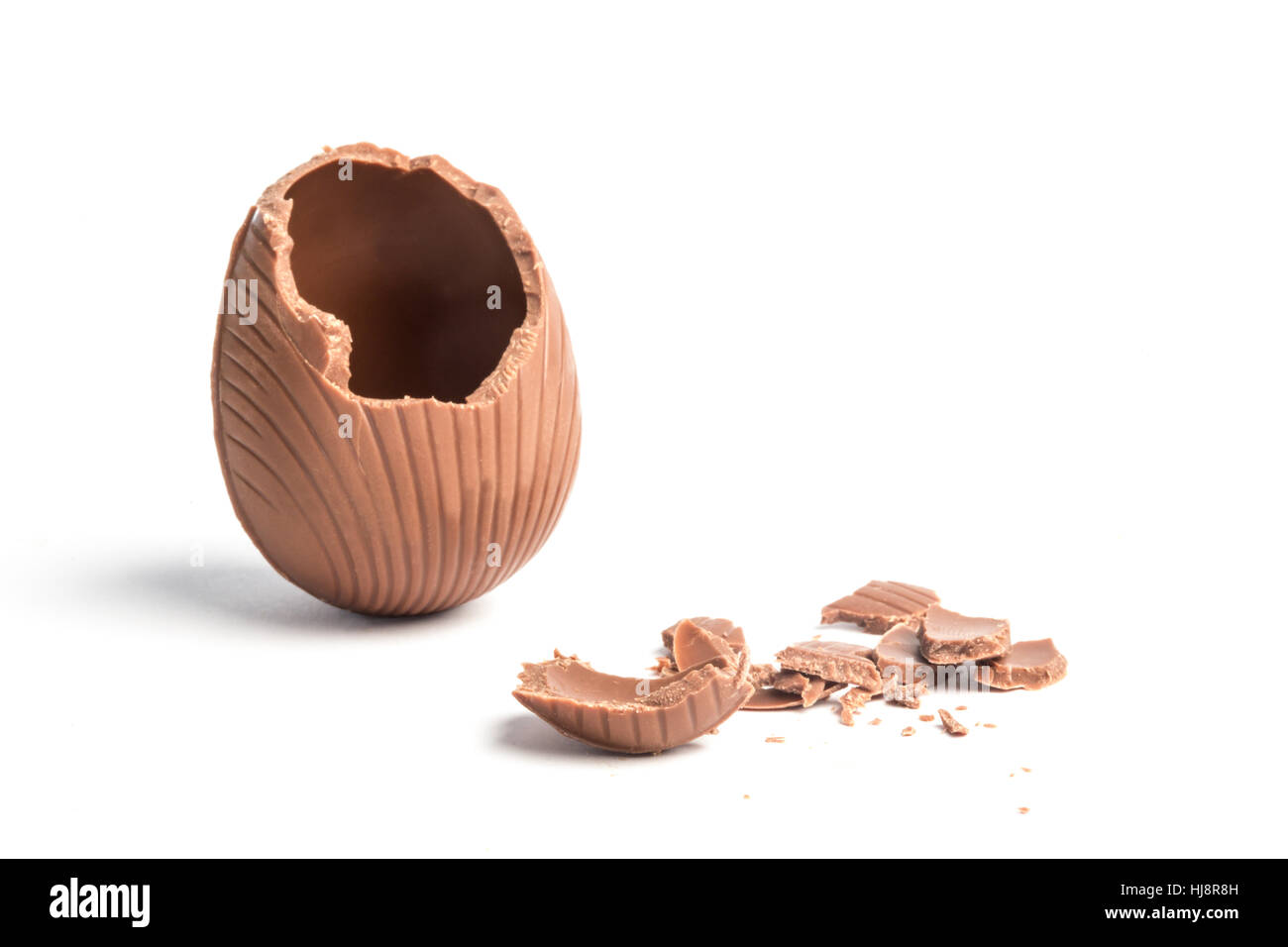 Broken chocolate easter egg on white background Stock Photo - Alamy