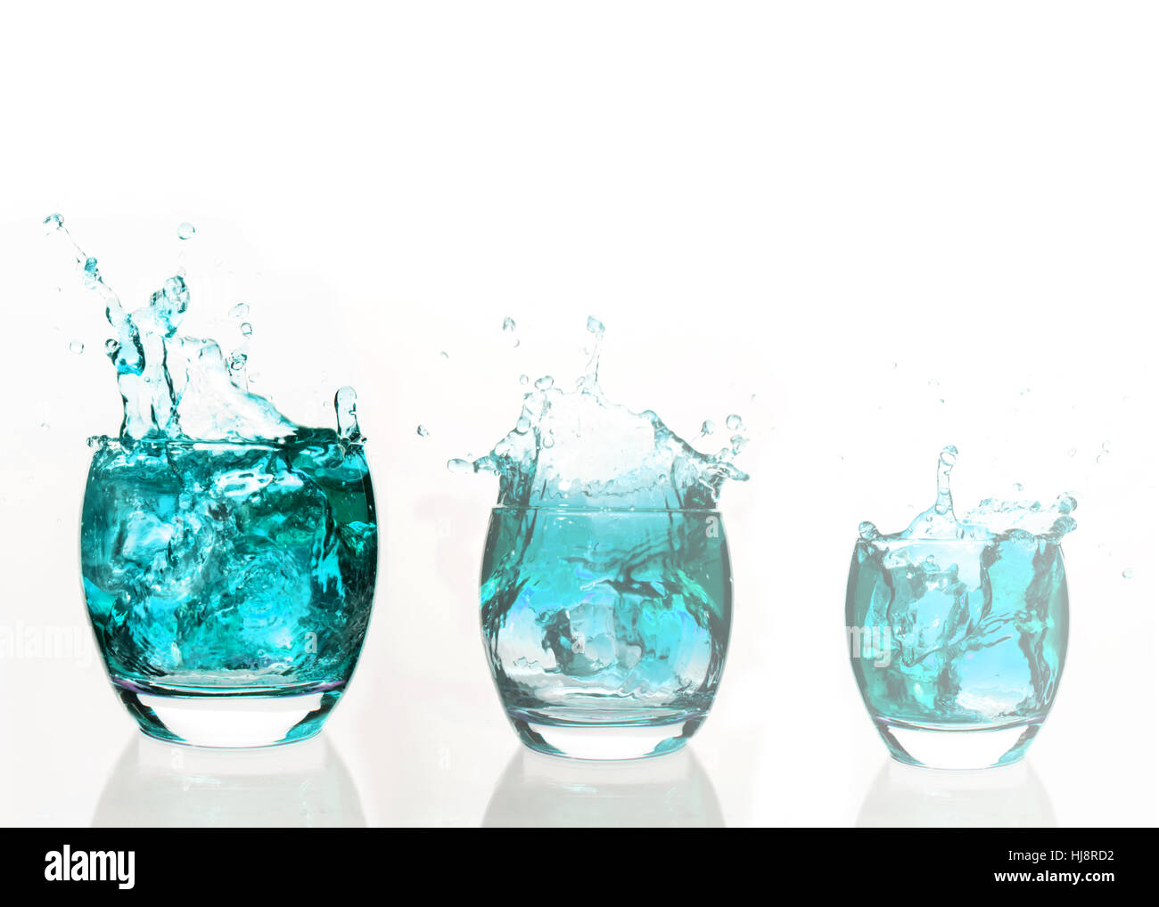 Serial arrangement of pale blue liquid splashing in tumbler on white ...