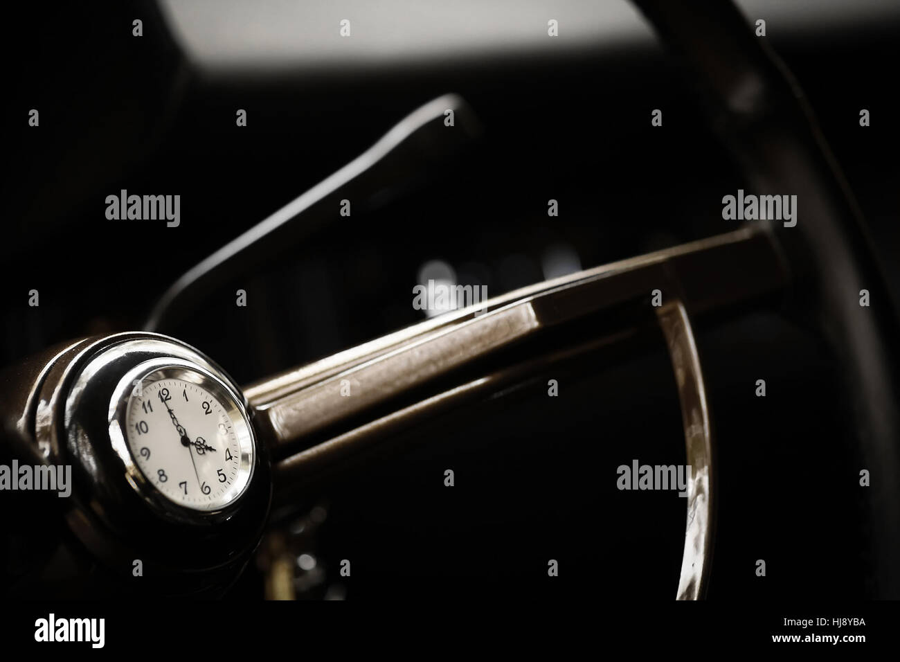 Detail of a clock installed on the steering wheel of a vintage car ...