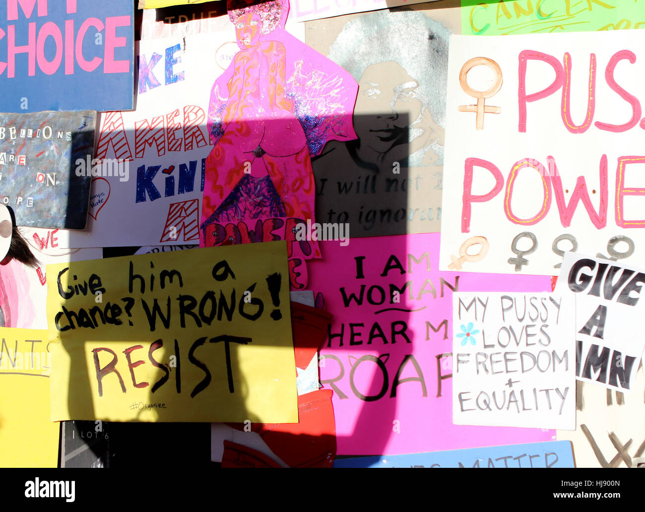 A shadow from a protesters sign is held up in front of a wall covered ...