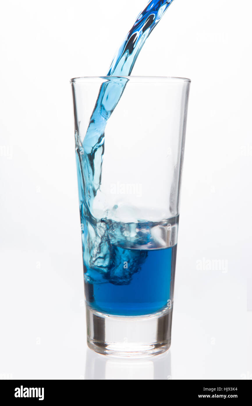 Glass being filled with blue liquid on white background Stock Photo - Alamy