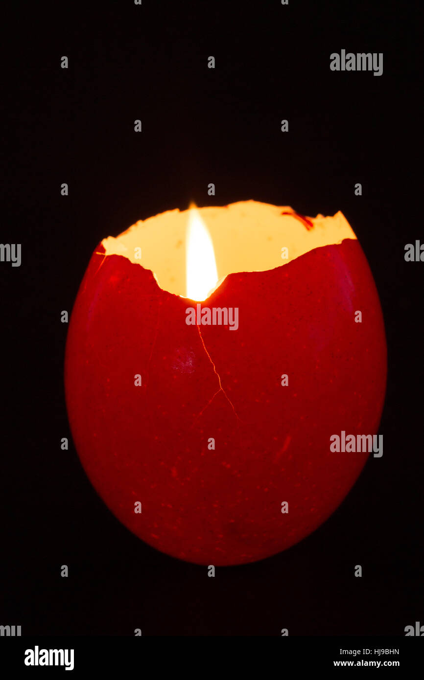 Red egg shell used as a candle holder on black background Stock Photo ...