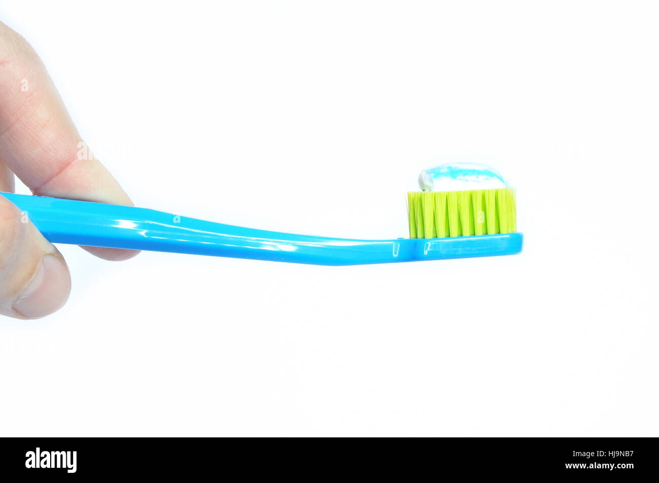 Toothbrush and toothpaste in hand, isolated Stock Photo - Alamy