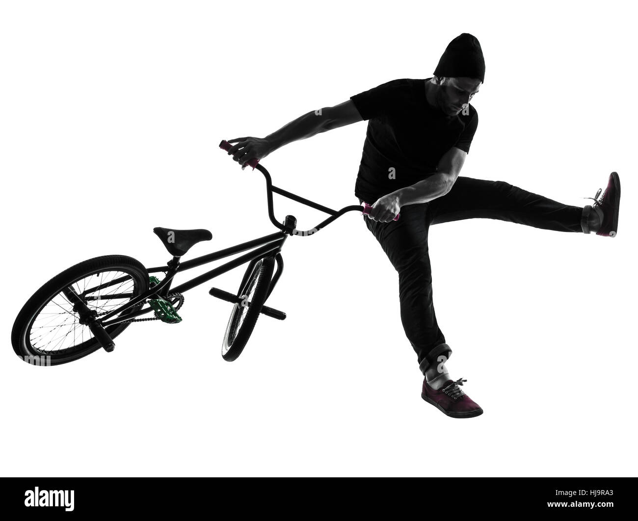 one caucasian man exercising bmx acrobatic figure in silhouette studio ...