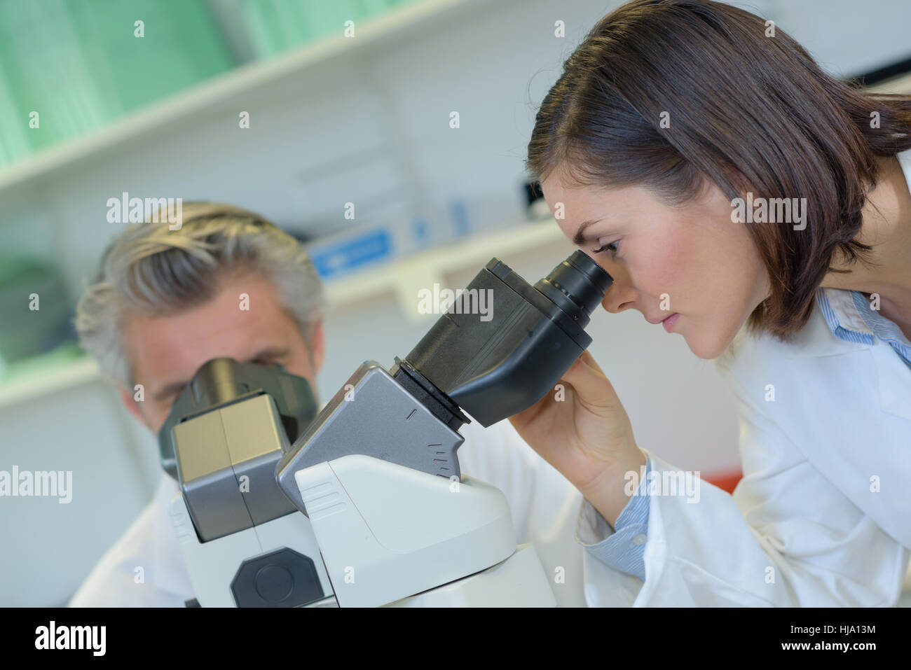 Woman looking into microscope Stock Photo - Alamy