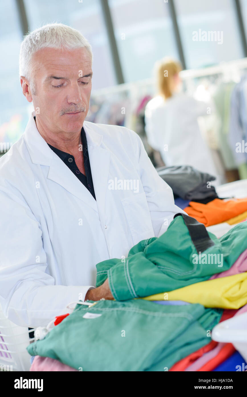 Senior man sorting laundry Stock Photo - Alamy
