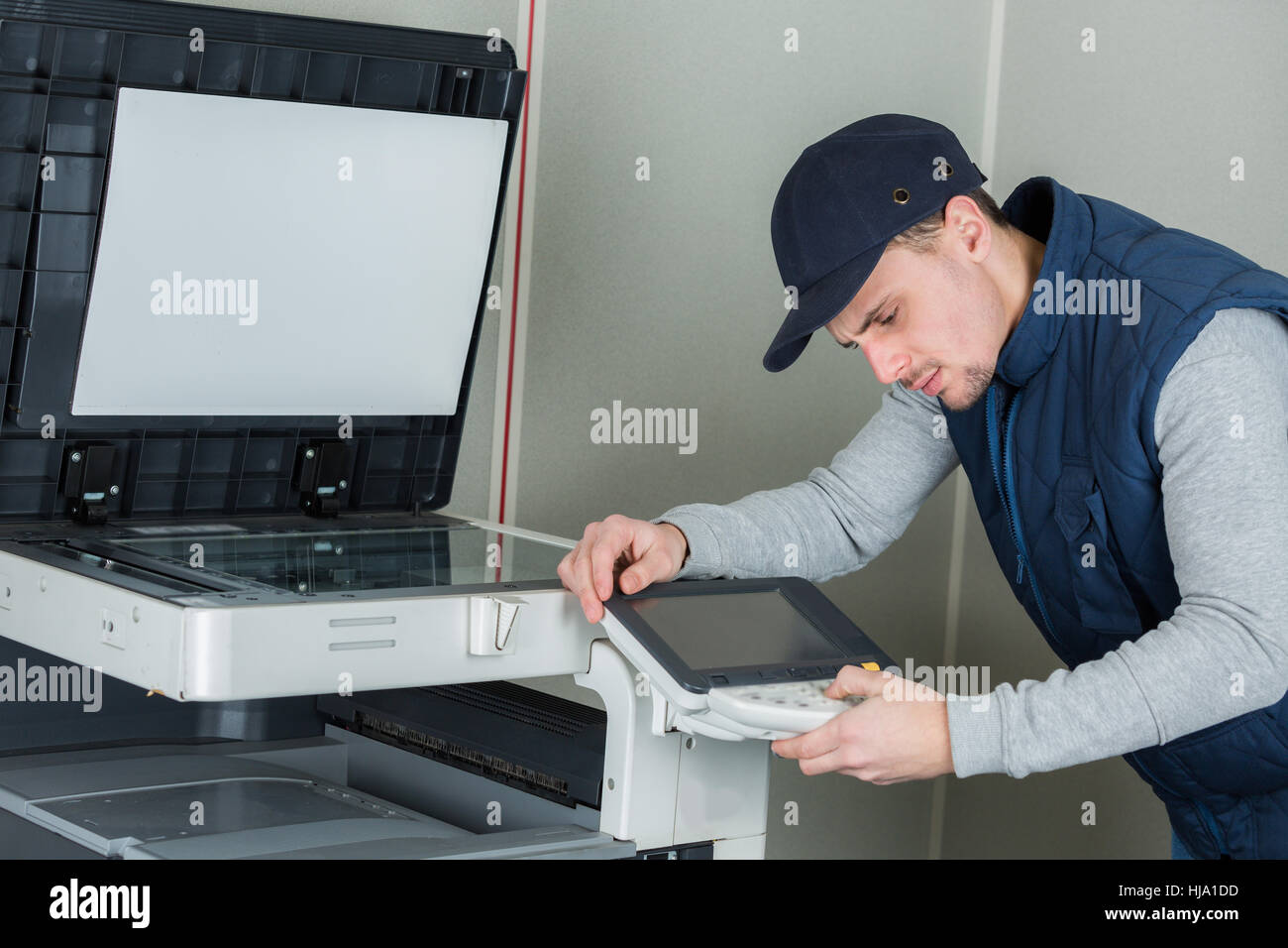 young male technician repairing digital photocopier printer machine ...