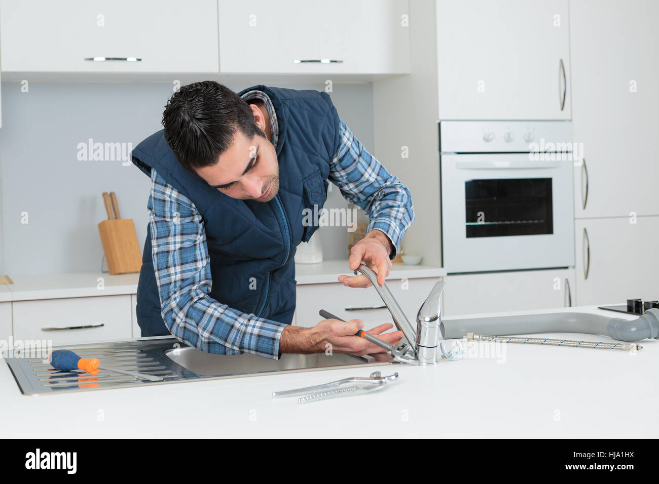 Plumber fitting kitchen tap Stock Photo - Alamy