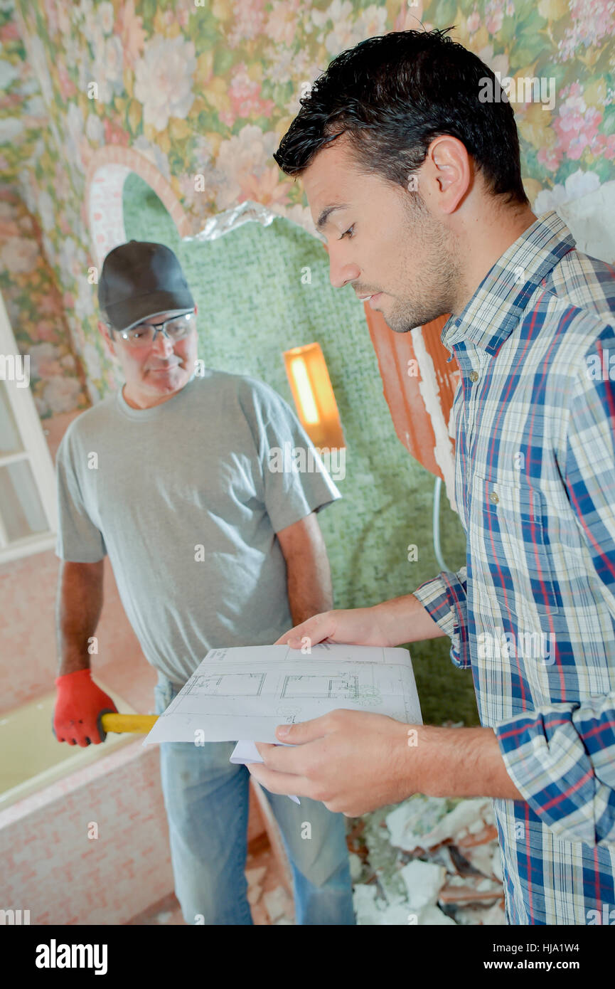 Builders checking the plans Stock Photo - Alamy