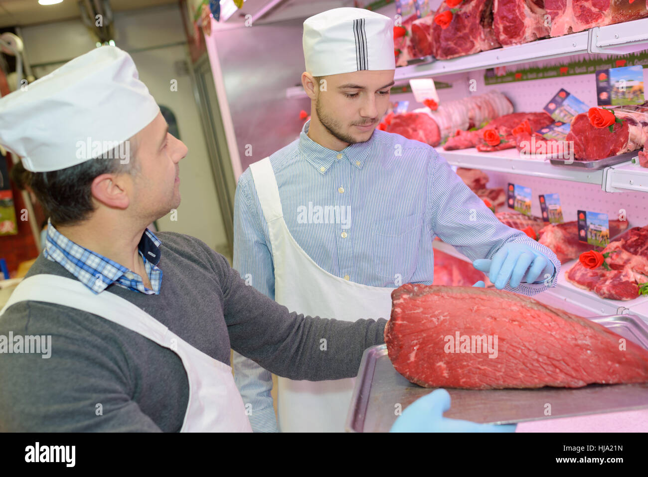 butcher teaching a young one how to sell meat Stock Photo - Alamy