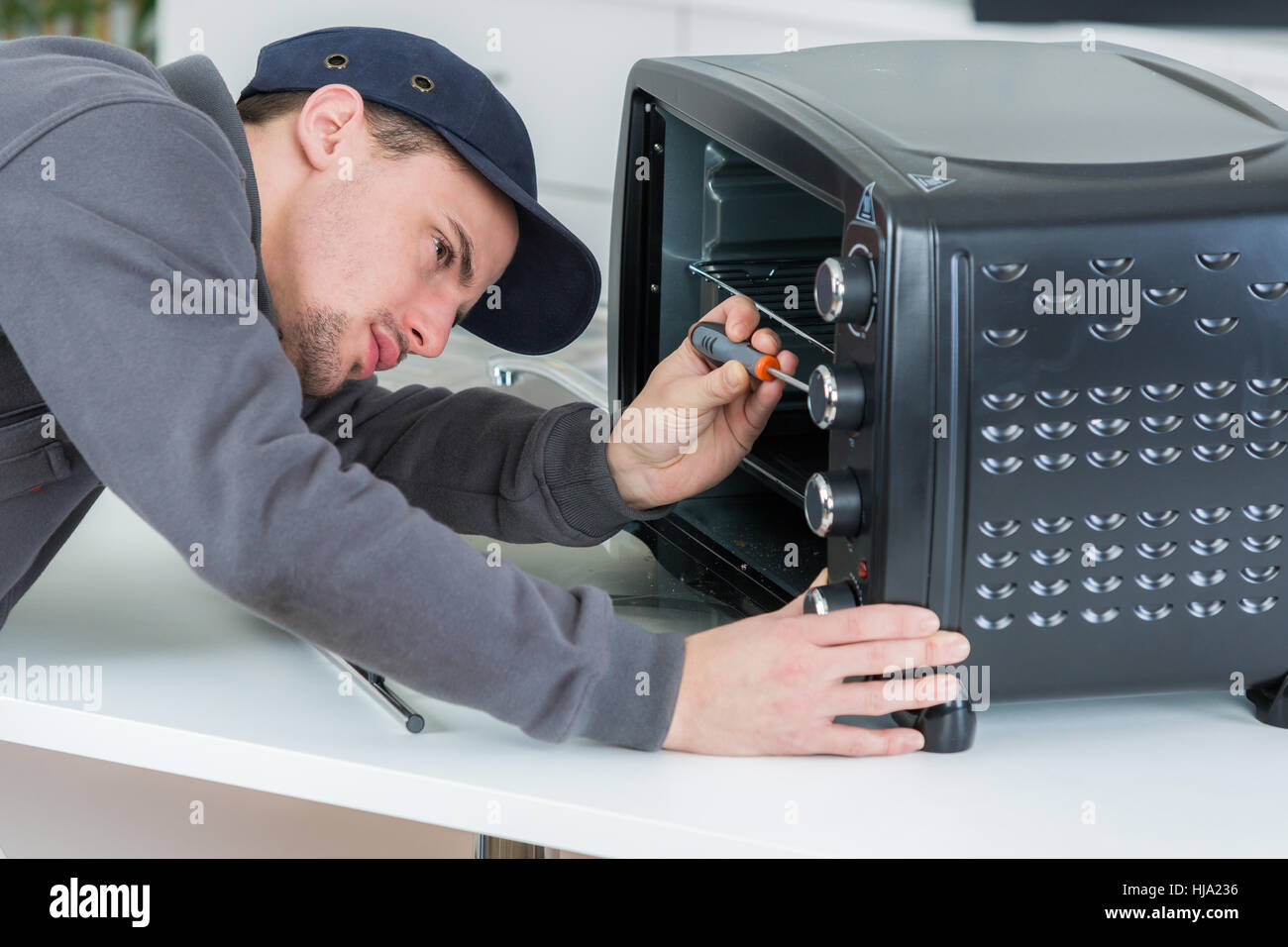handyman fixing a portable oven Stock Photo - Alamy