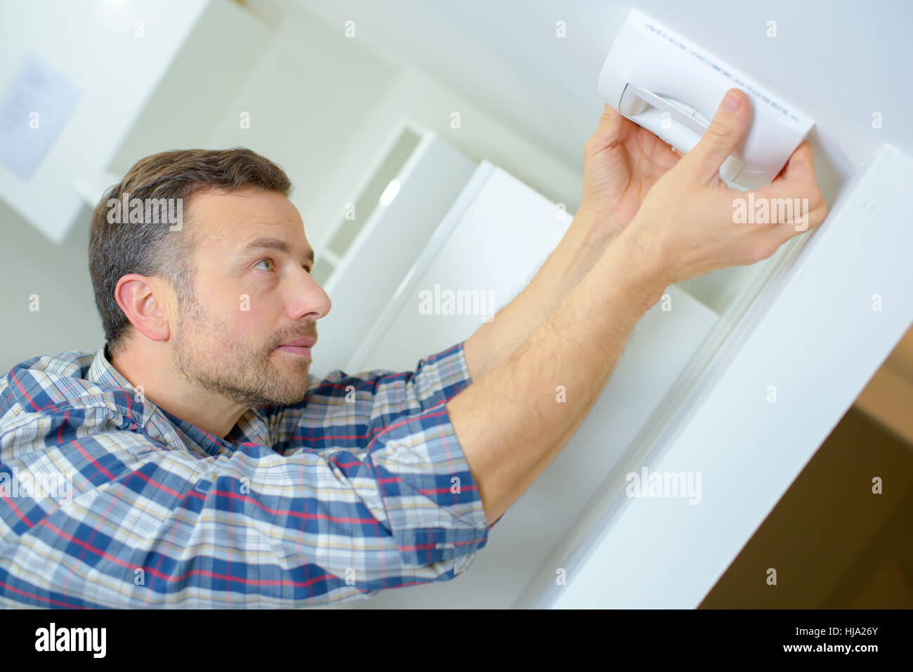 Man fitting an air vent Stock Photo - Alamy