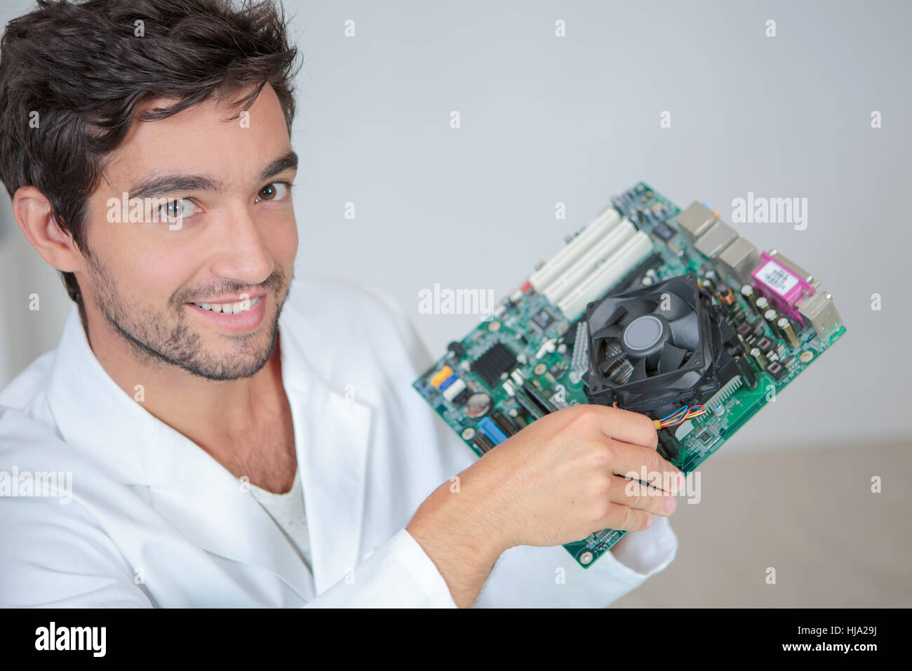 Portrait of man holding computer component Stock Photo - Alamy