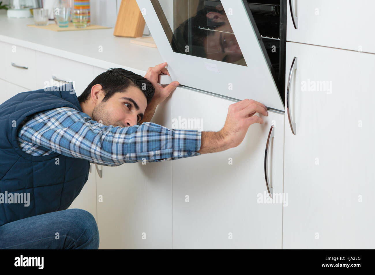 Man fitting new oven Stock Photo - Alamy