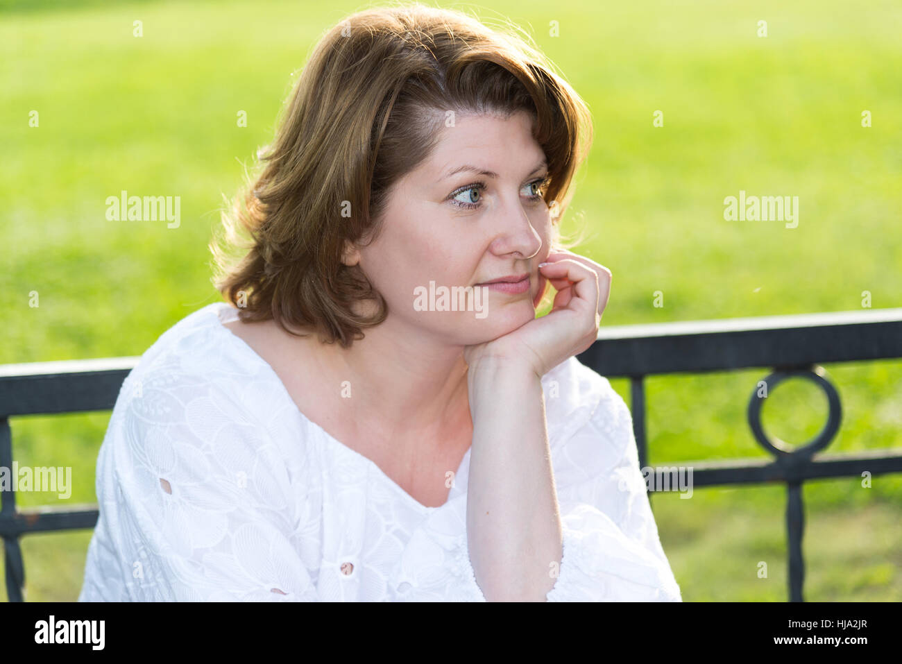 Cheerless woman in park on a bench Stock Photo - Alamy