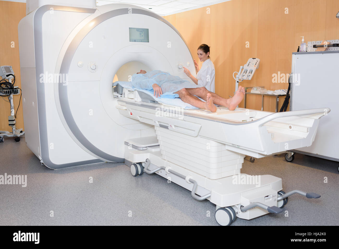 Nurse programming scanner as patient enters tunnel Stock Photo - Alamy
