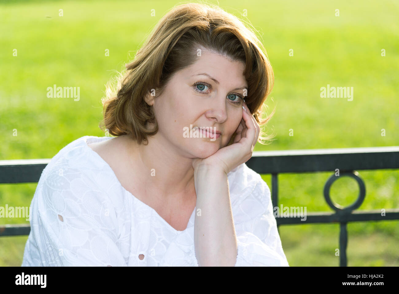 Cheerless woman in park on a bench Stock Photo - Alamy