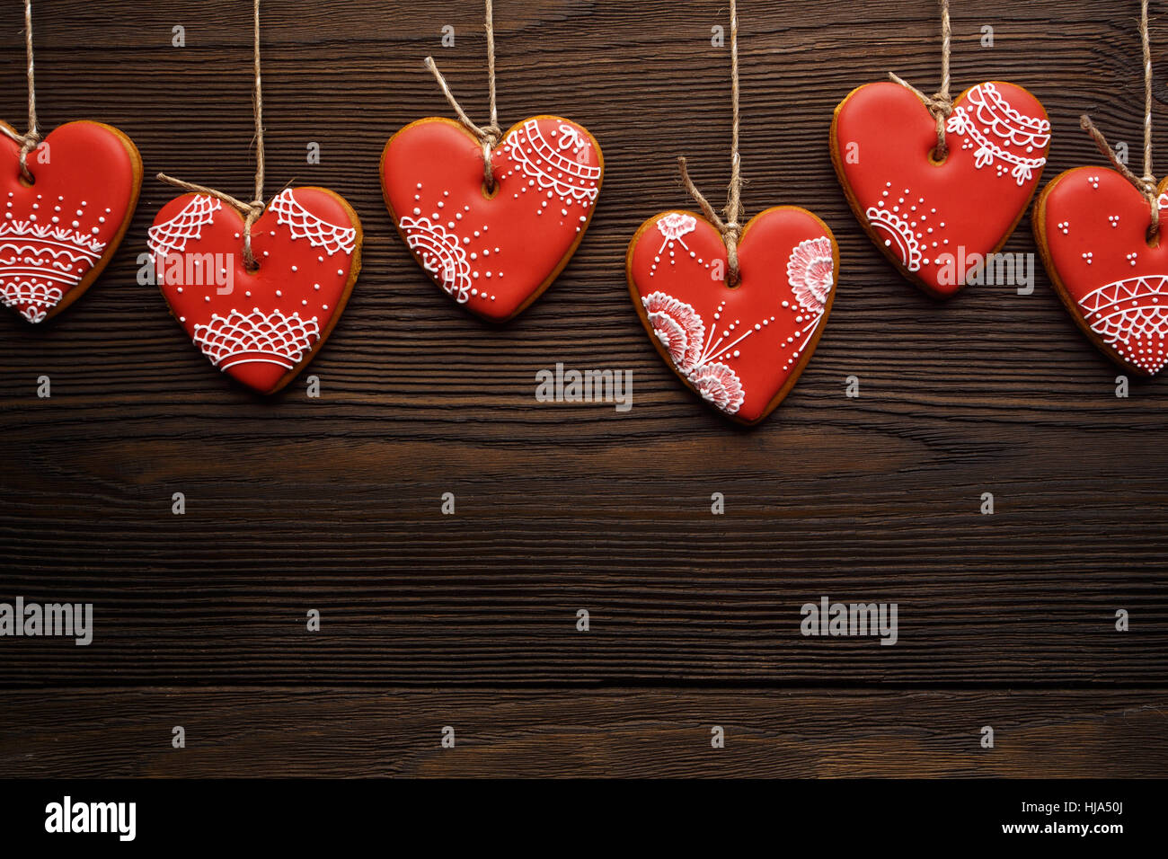 Line of red gingerbreads hearts on ribbon Stock Photo - Alamy