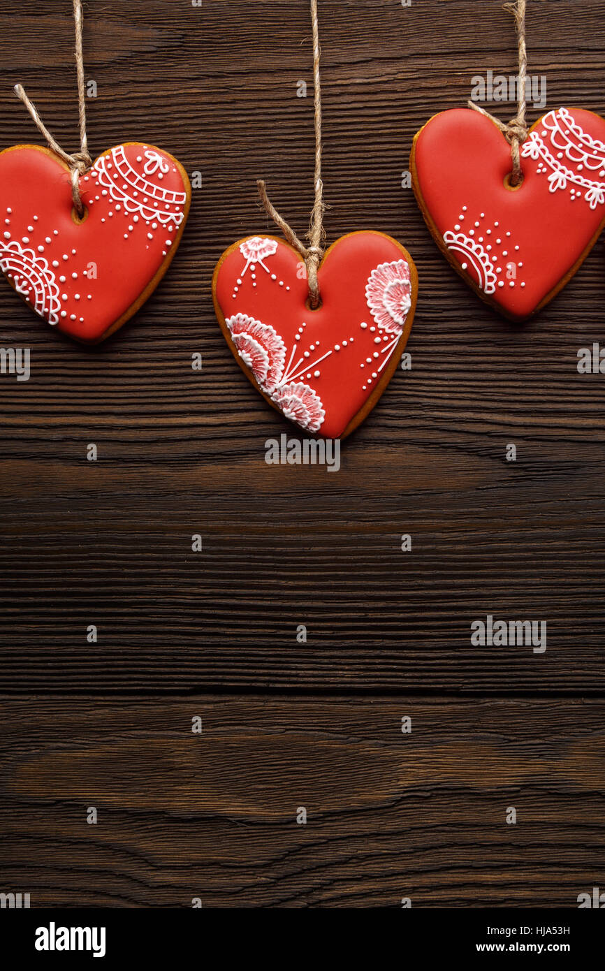 Line of red gingerbreads hearts on ribbon Stock Photo - Alamy