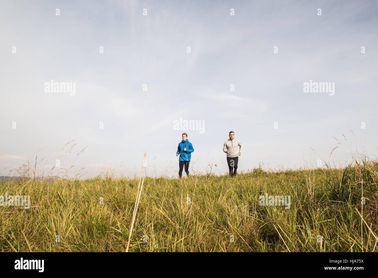 Two young hipster athletes running in sunny autumn nature Stock Photo ...