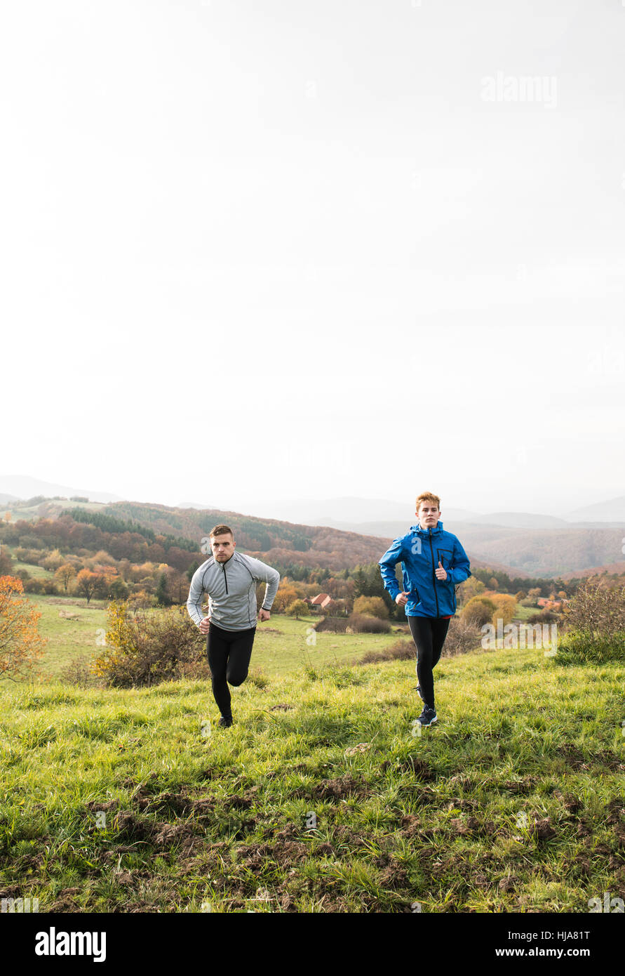 Two young hipster athletes running in sunny autumn nature Stock Photo ...