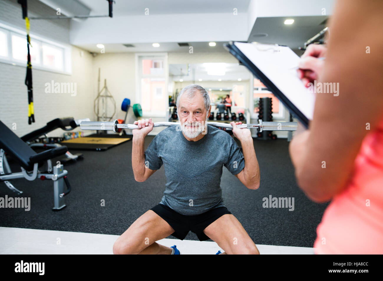 Senior man in gym working out with weights Stock Photo - Alamy