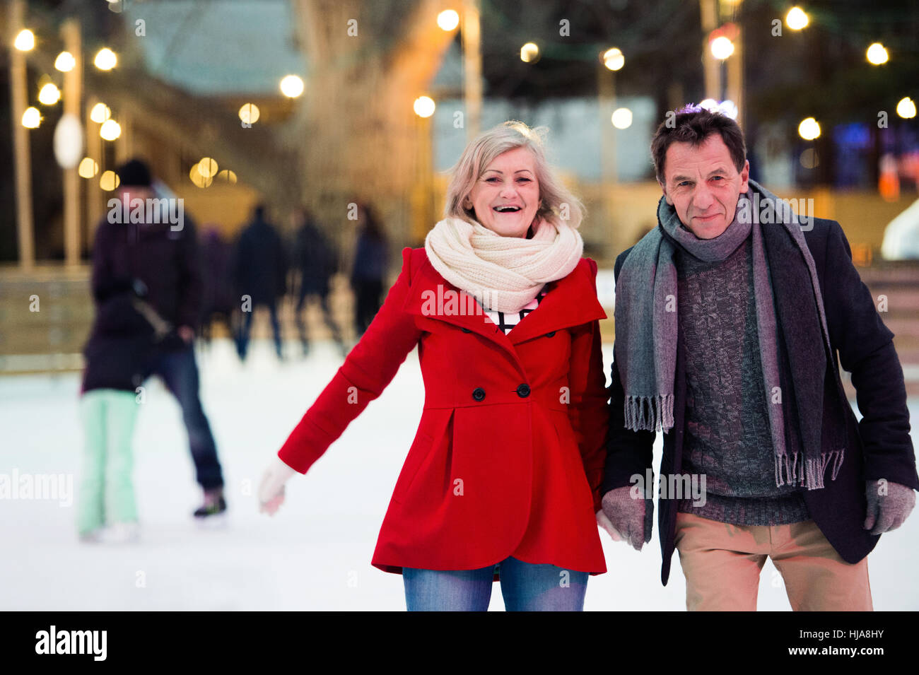 Beautiful senior couple ice skating in city centre. Winter Stock Photo ...