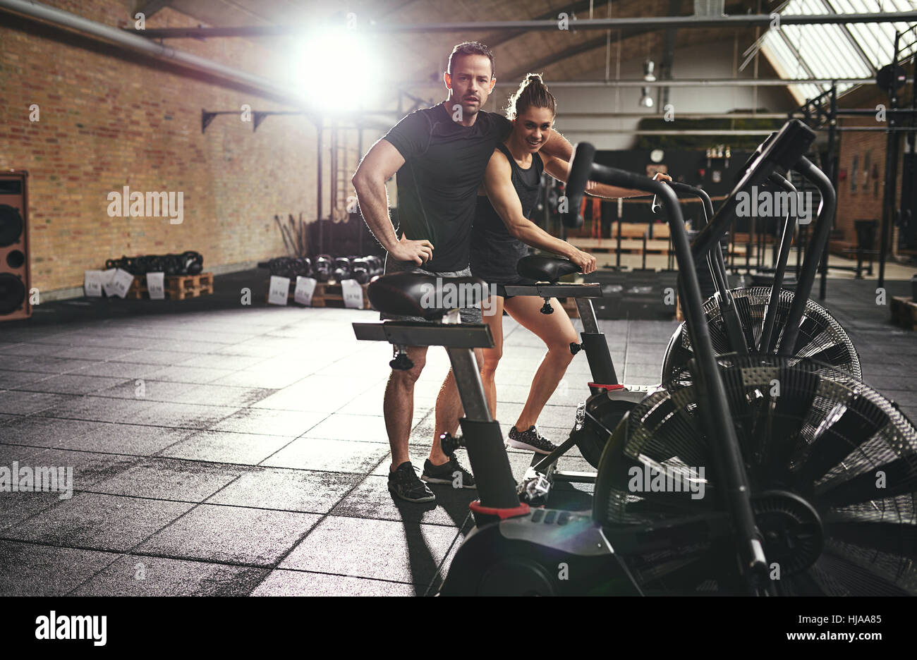 Young male and female happily hugging after hard workout on training ...