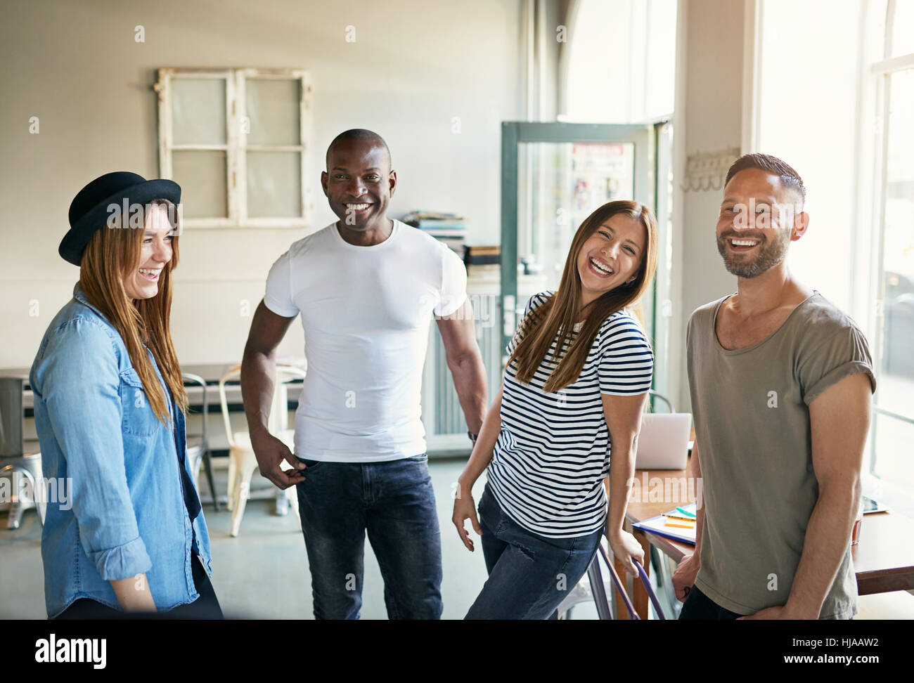 Group of four young smiling people wearing stylish casual clothing ...
