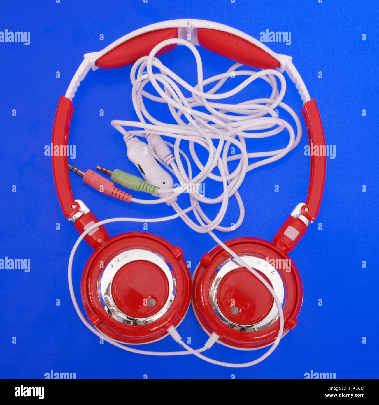 Red headphones with wires on blue background Stock Photo - Alamy