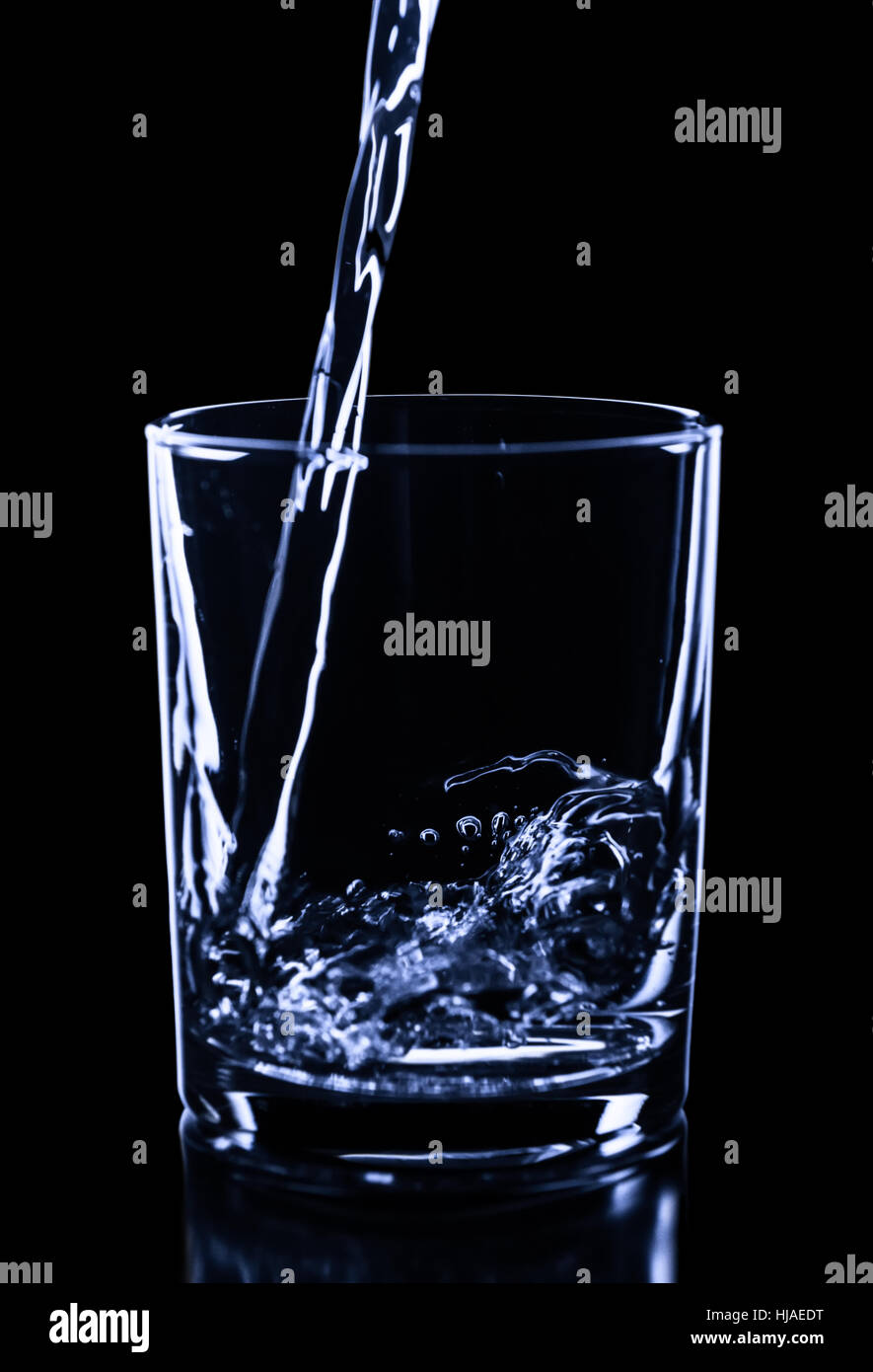 pouring blue water on glass isolated on black, close up, concept moon ...