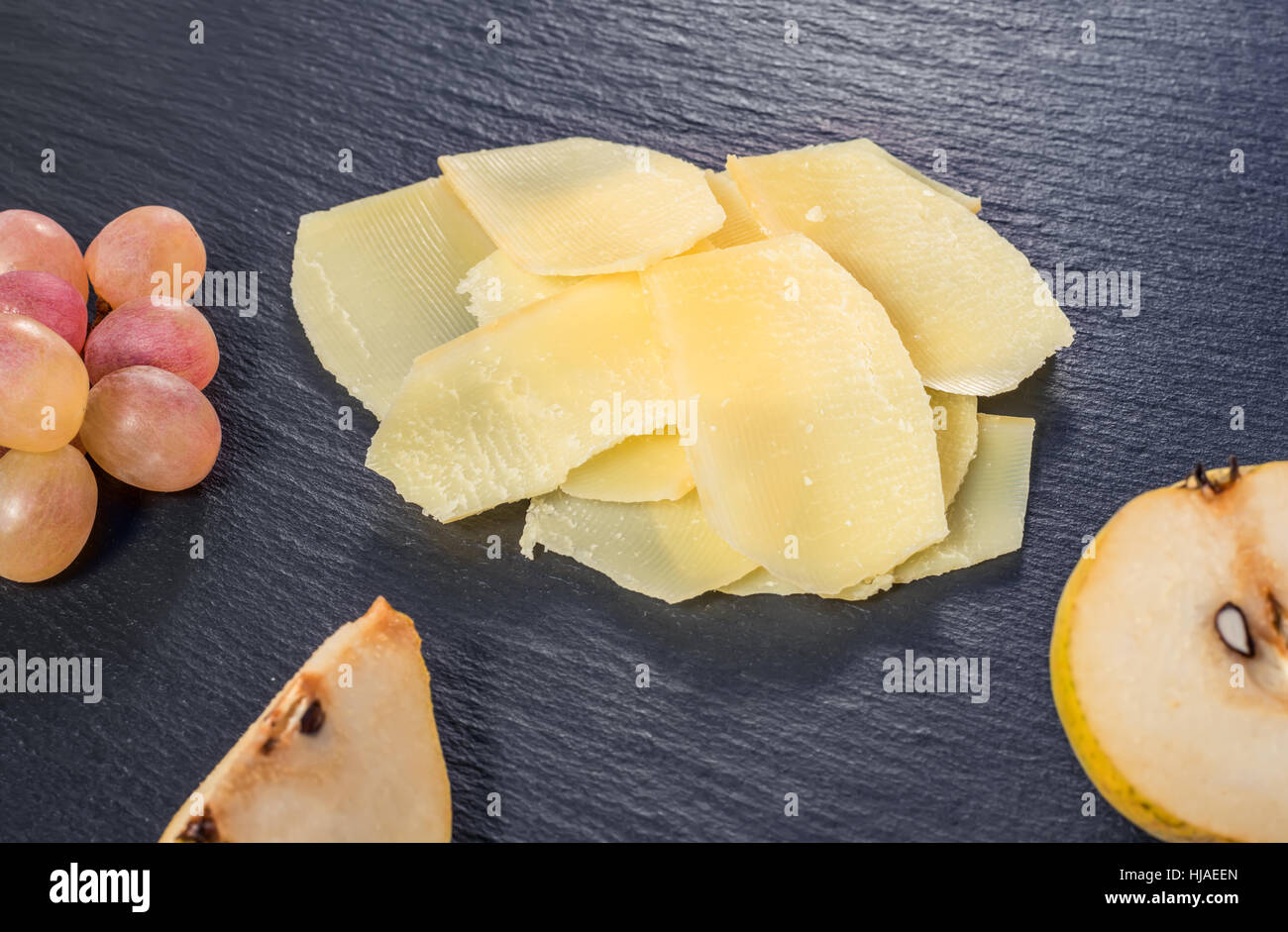 top view of tasty fresh yellow thin slice parm cheese, cuted pear and ...
