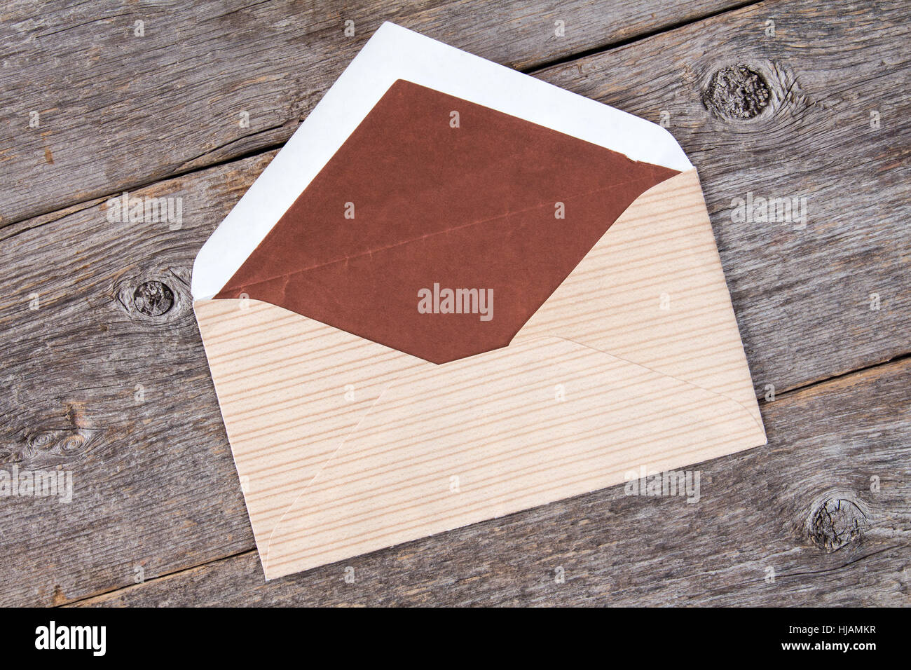 Open brown envelope lying on wooden background Stock Photo - Alamy