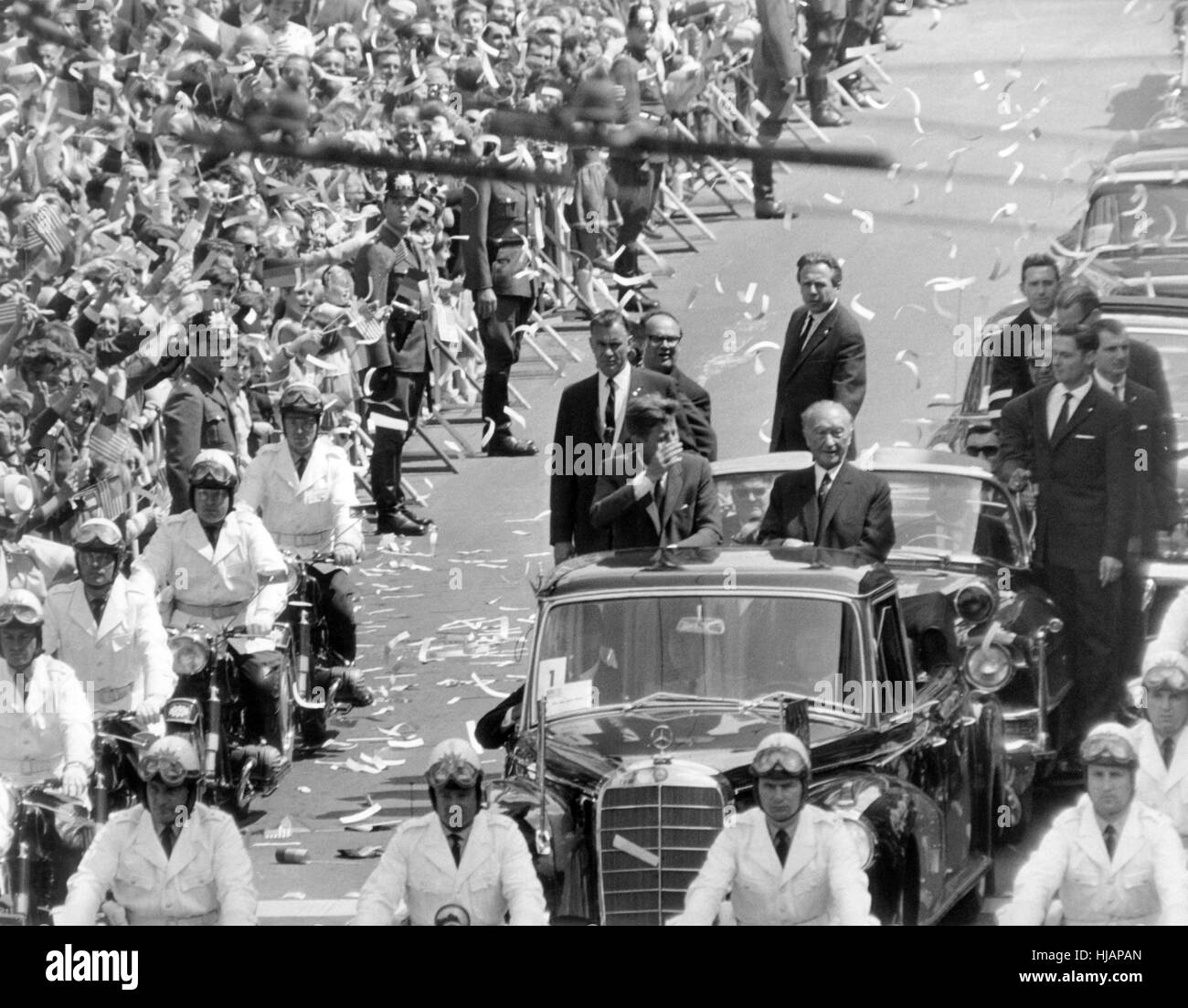 The American president John F. Kennedy (standing in the car and waving ...