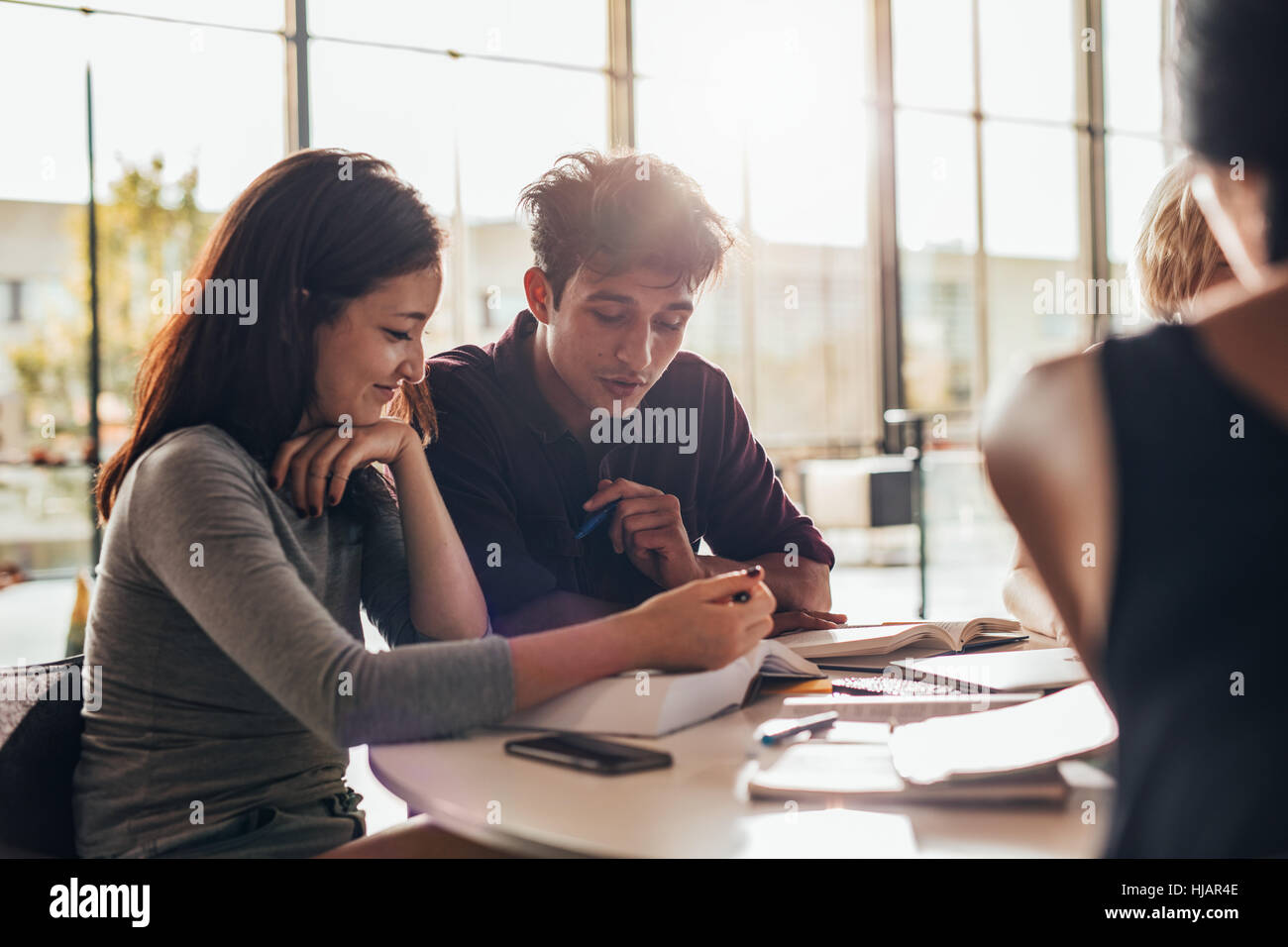 Two young students reading a book in library. university students ...