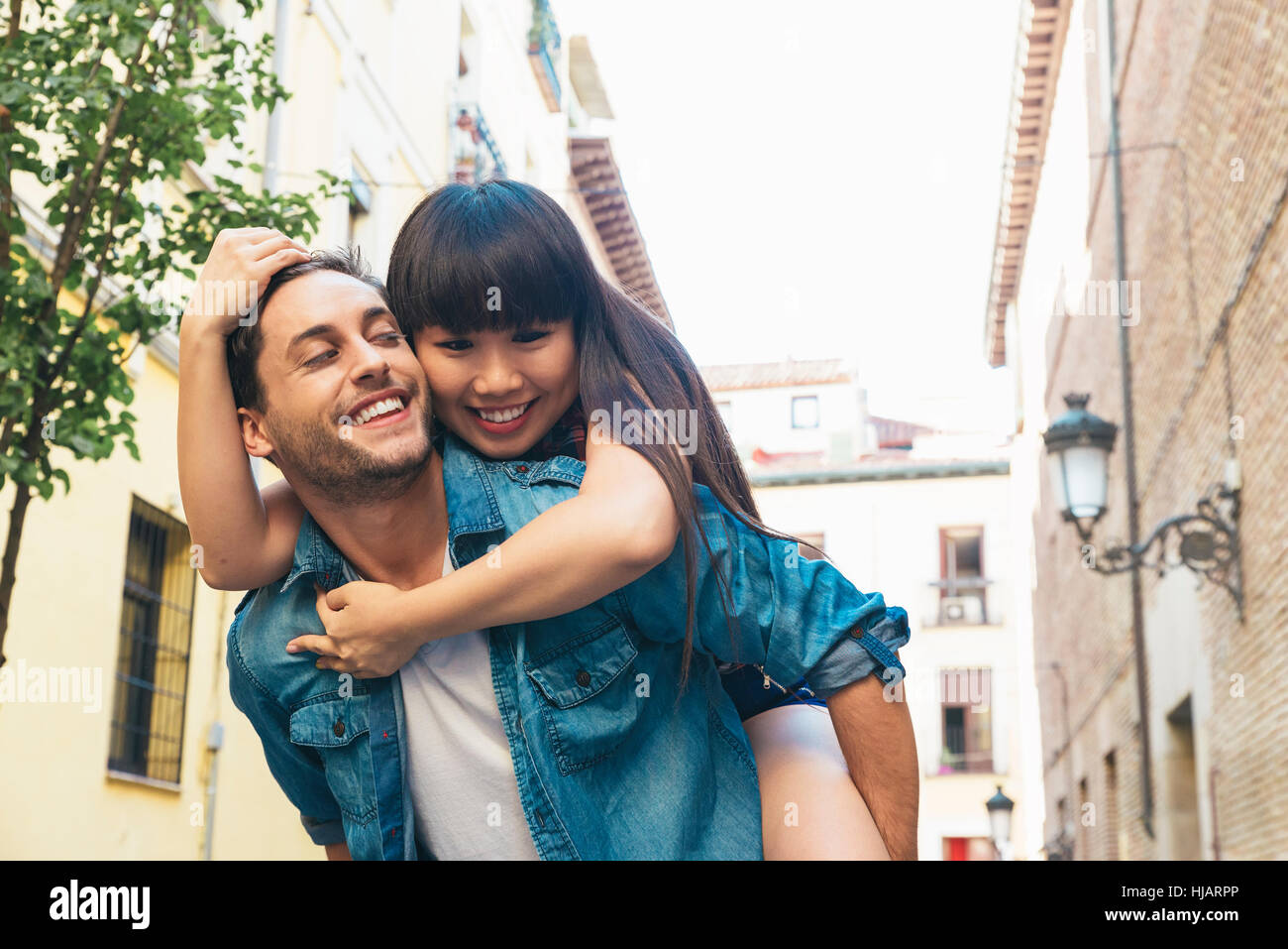 Happy loving couple. Happy young man piggybacking his girlfriend while ... Happy loving couple. Happy young man piggybacking his girlfriend while ...