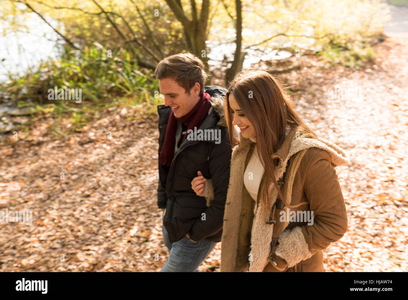 Young couple walking in park, arm in arm, smiling Stock Photo - Alamy