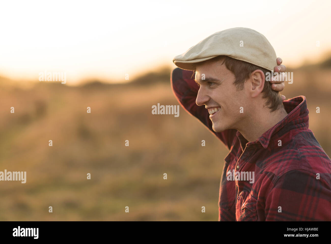 Young man in rural setting, smiling, side view Stock Photo - Alamy