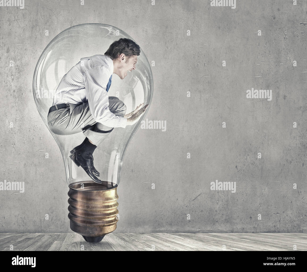 Screaming businessman trapped inside of light bulb Stock Photo - Alamy