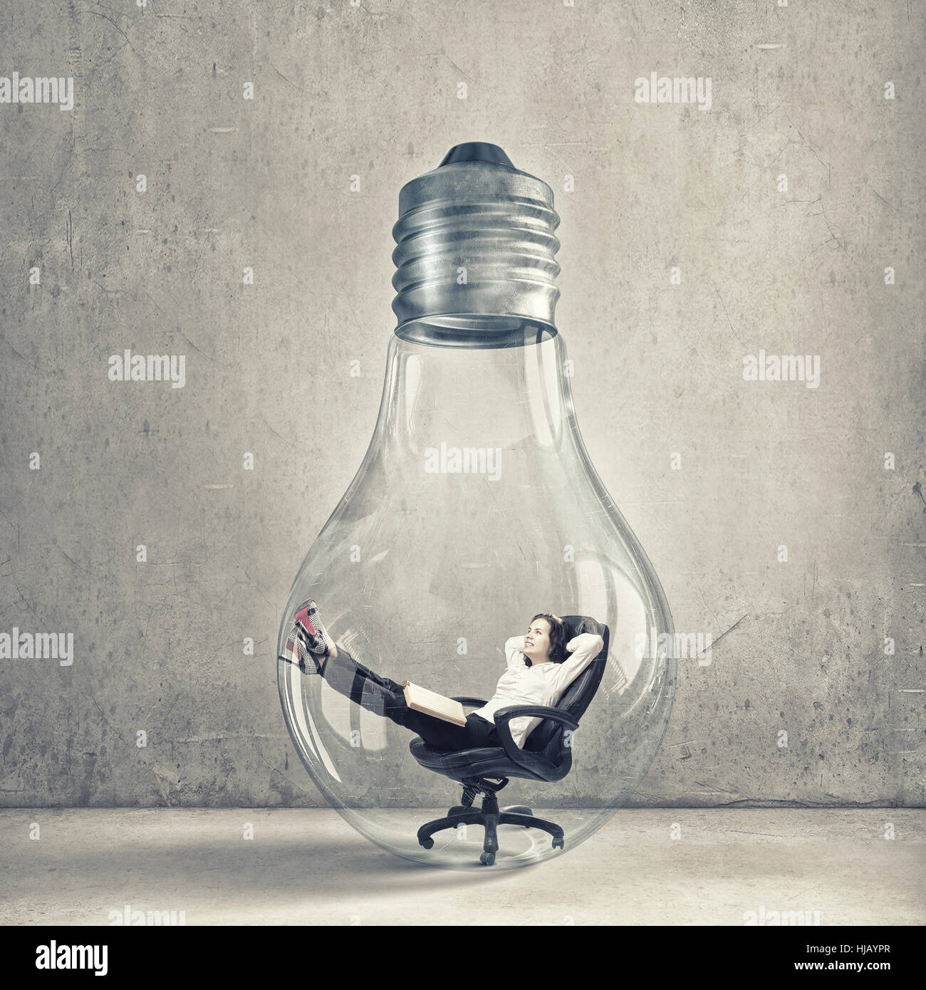 Relaxed businesswoman sitting inside of glass light bulb Stock Photo ...