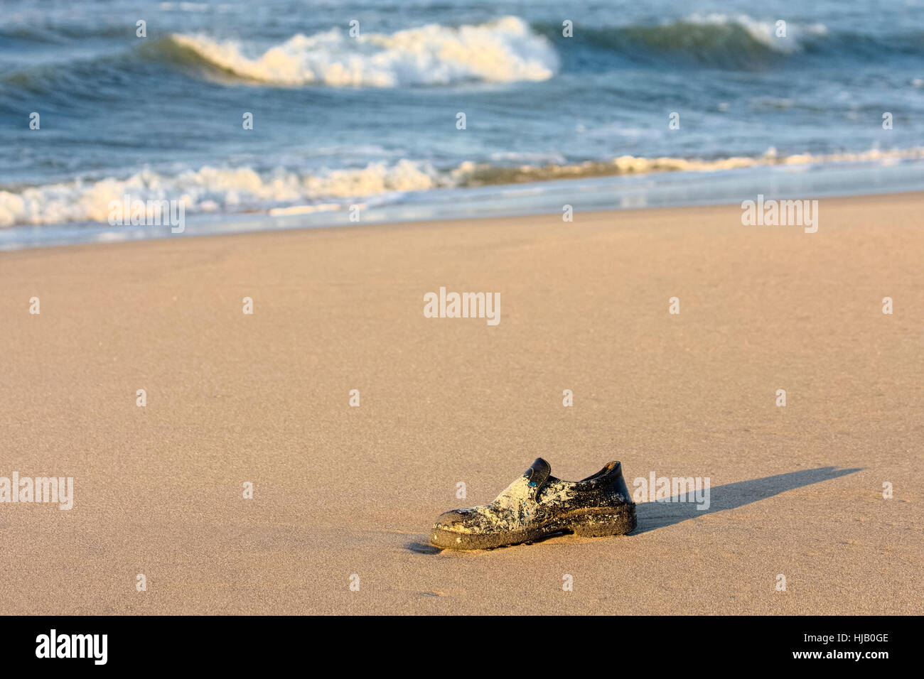 shoe on the beach with waves in the background Stock Photo - Alamy