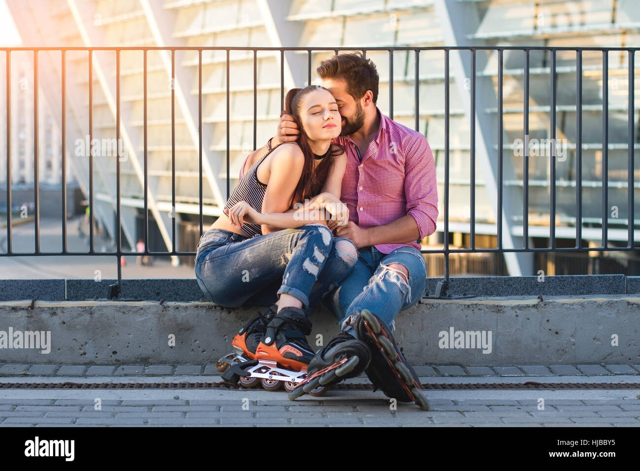 Couple of inline skaters sitting Stock Photo - Alamy