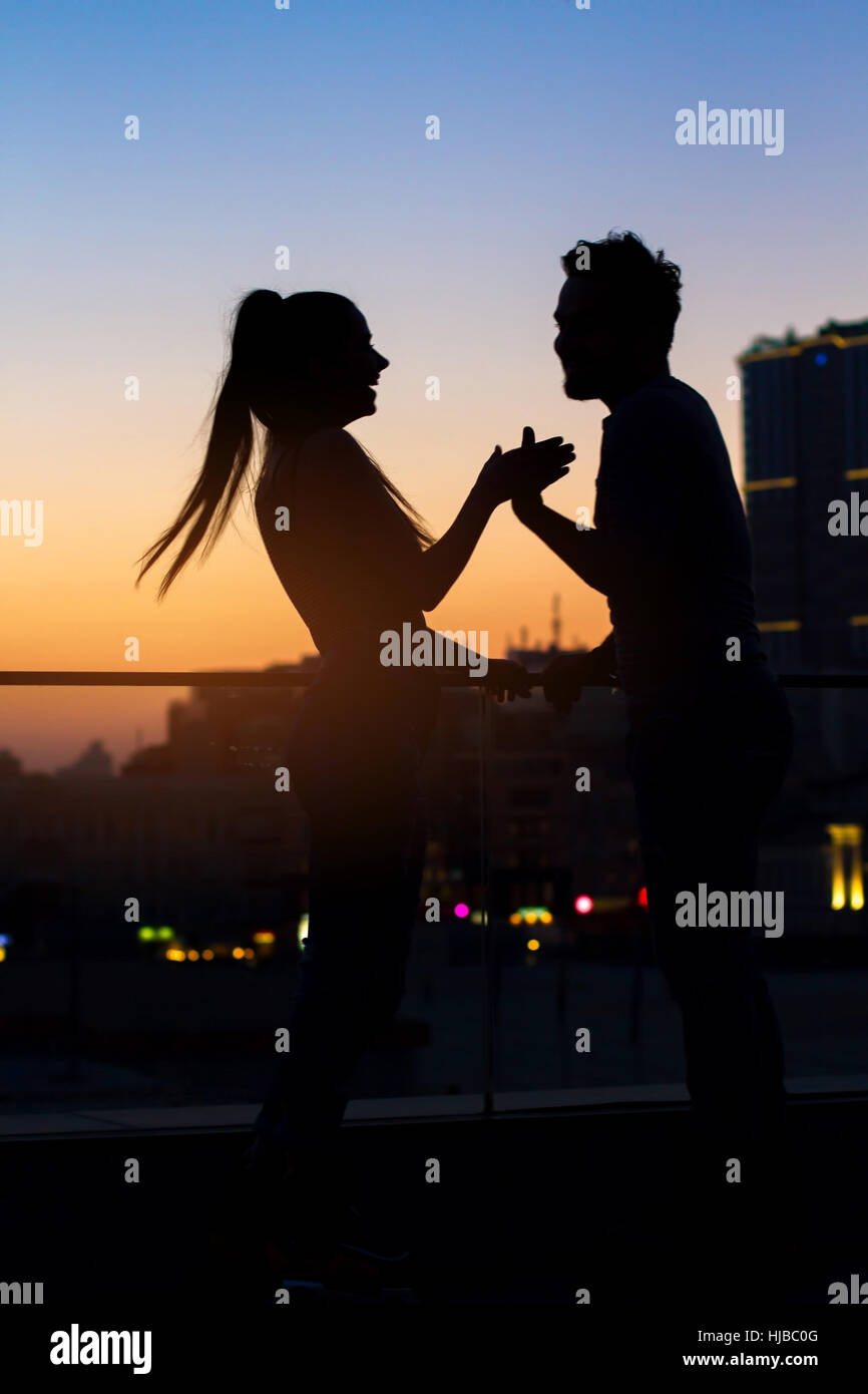 Couple on sunset sky background Stock Photo - Alamy